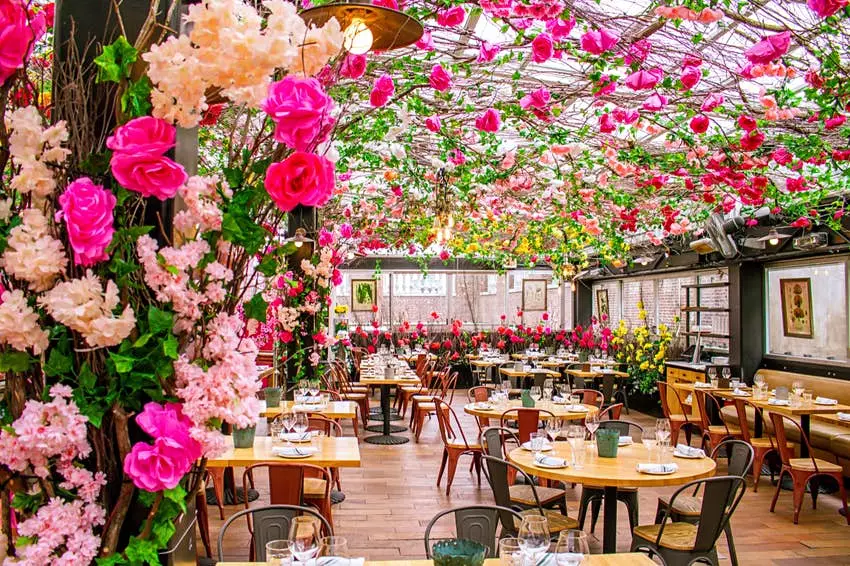 Ružové a biele kvety obklopujú mriežku obklopujúcu Serra Fiorita; najlepšie strešné bary v New Yorku