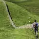 Turista kráčajúci popri Hadriánovom múre neďaleko Crag Lough v Northumberlande v Anglicku