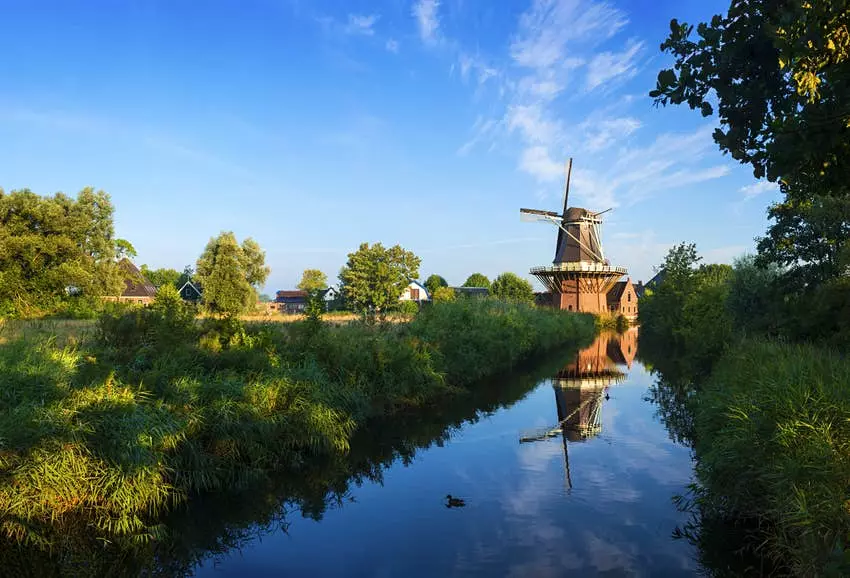 Tradičný holandský veterný mlyn pozdĺž kanála neďaleko Alkmaaru v Holandsku
